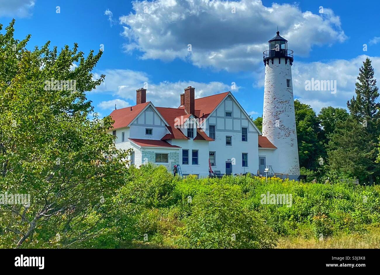 Beautiful lighthouse and building along the shoreline along Pictured ...