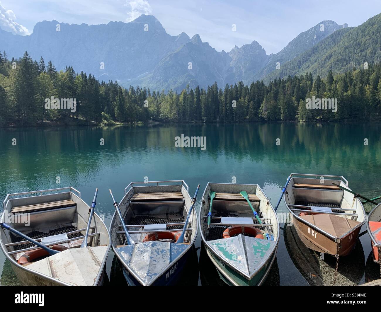 Metal row boats on lake fuzine Italy Stock Photo - Alamy