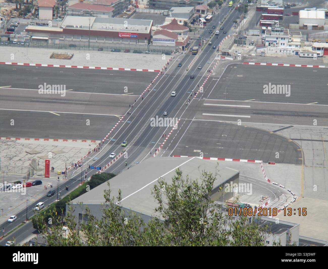Gibraltar airport runway with the main road crossing Stock Photo - Alamy