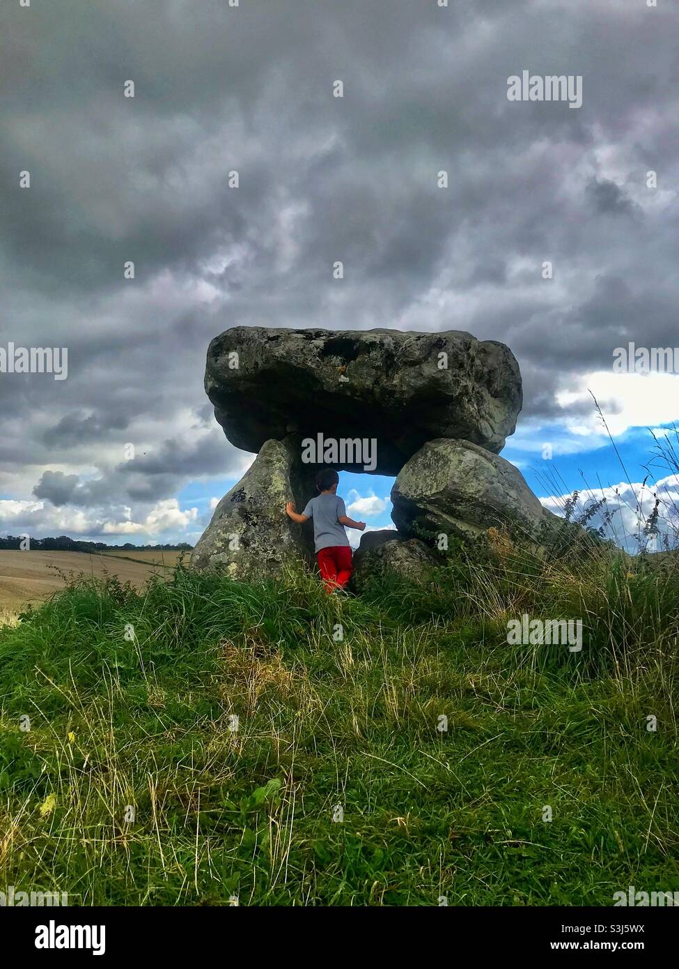 A child playing at Devil’s Den Burial chamber on the Downs, Marlborough ...