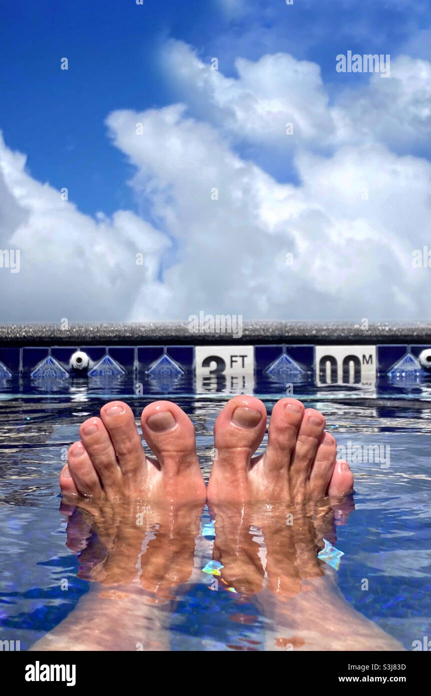 Two feet sticking out of the water at the 3 foot end of an outdoor ...