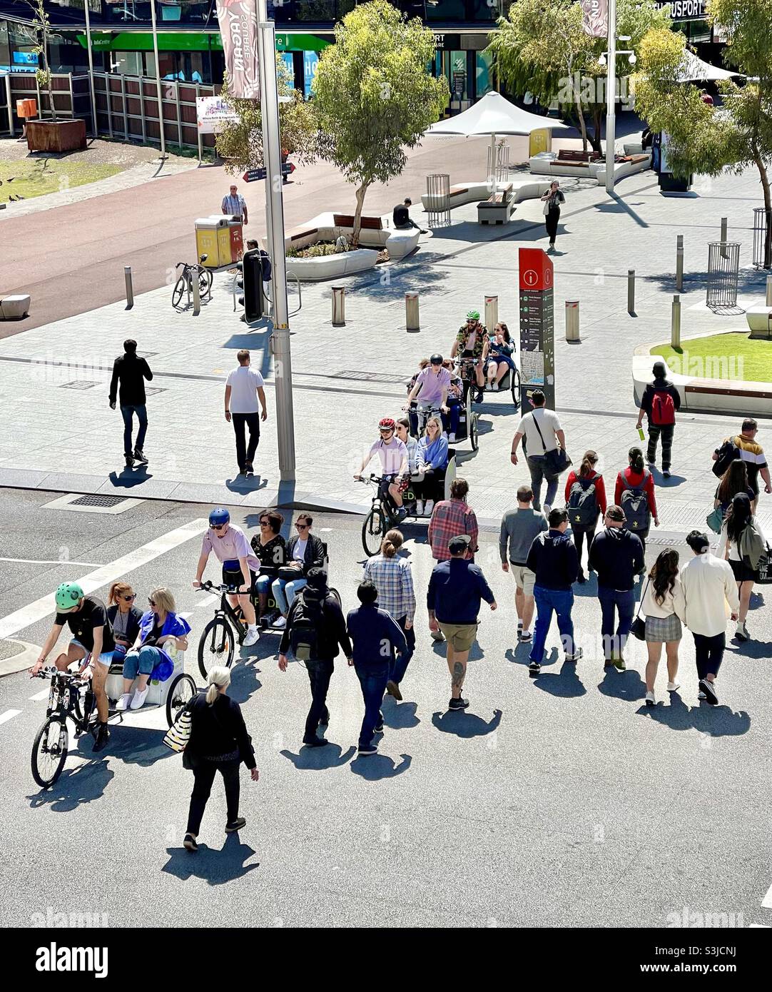 Tourists touring on tricycles and pedestrians crossing Wellington ...
