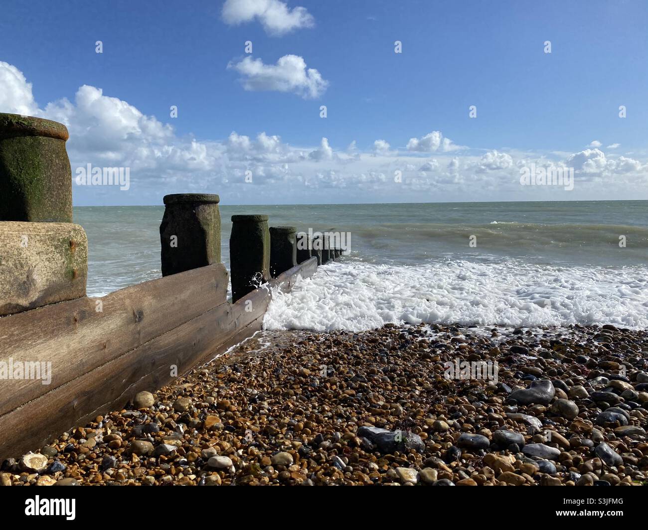 Wooden sea defence with wave Stock Photo - Alamy