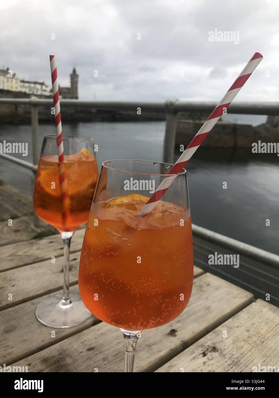 Aperol Spritz cocktail with a red and white striped paper straw, in the ...