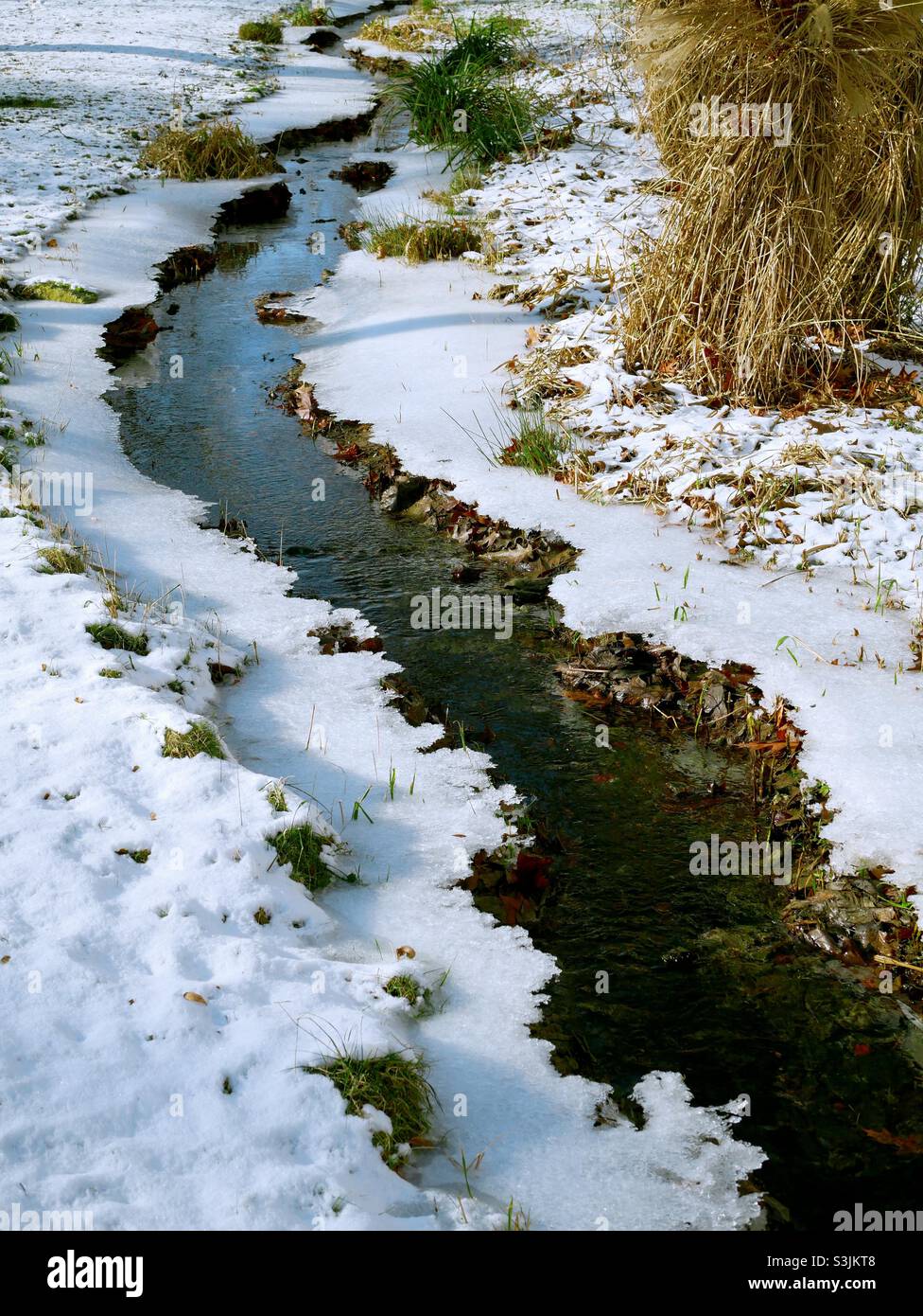 Small brook winding through winter landscape Stock Photo - Alamy