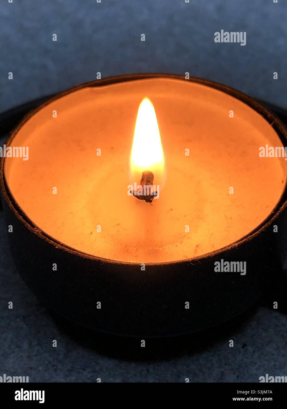 Small flame on a small candle. Beautiful colors. Nice background Stock ...