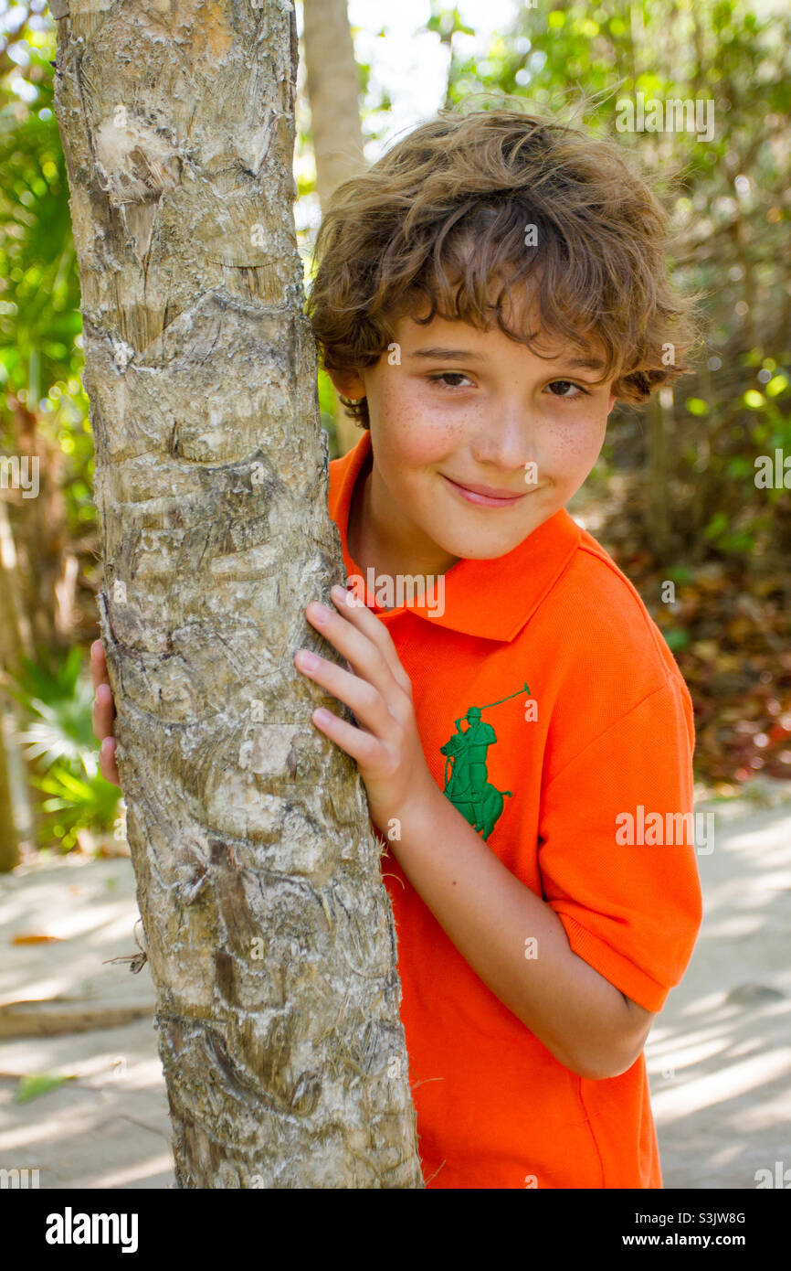 Boy behind tree hi-res stock photography and images - Alamy