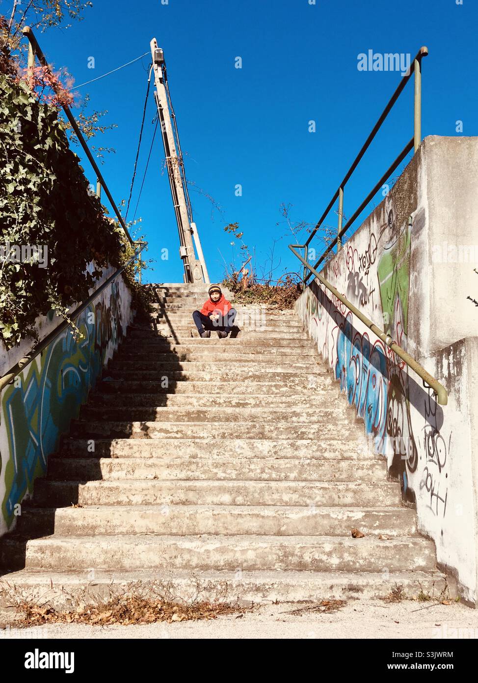 Boy child sitting on stairs, suburban feeling Stock Photo - Alamy