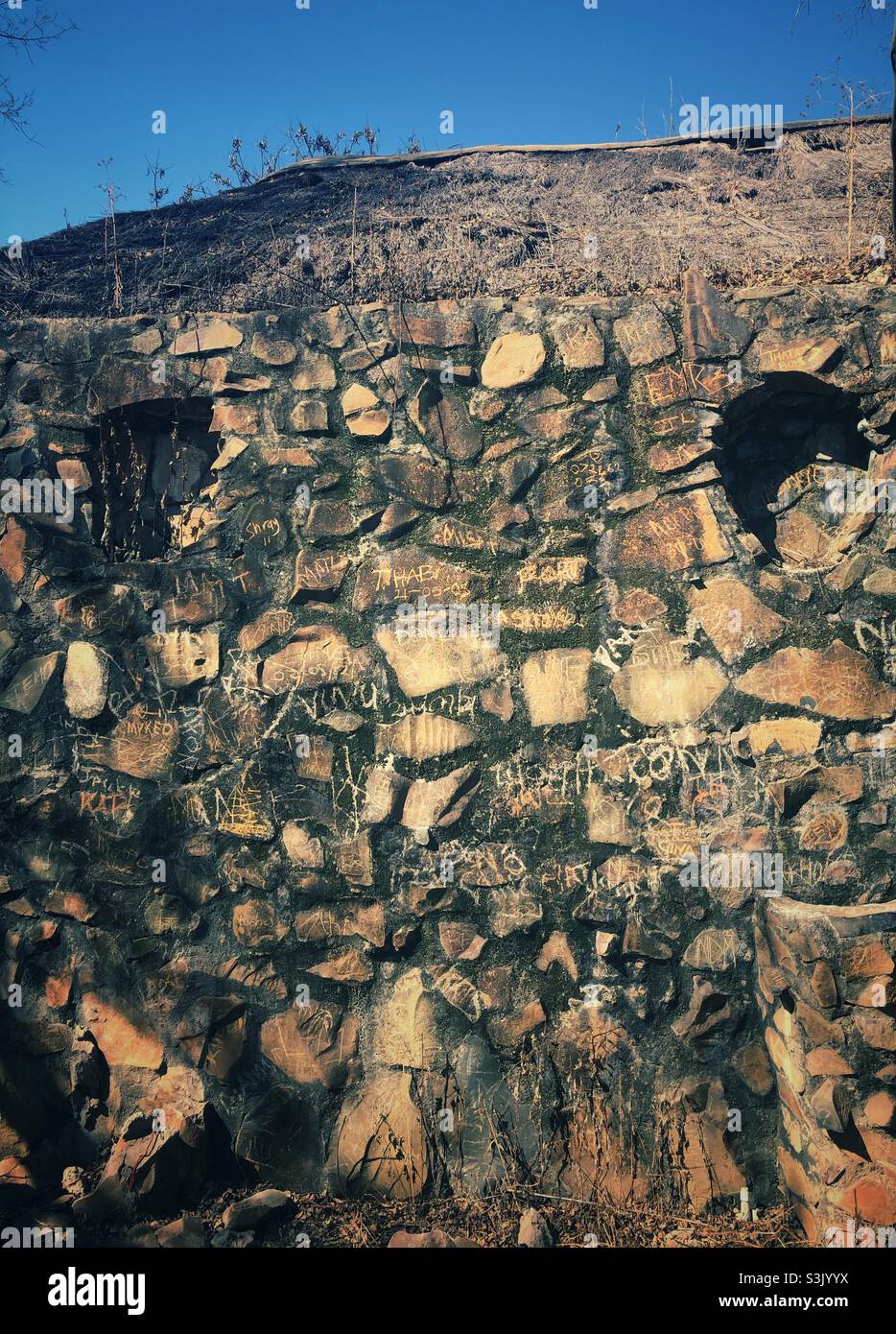 Modern day graffiti on an old stone wall Stock Photo - Alamy