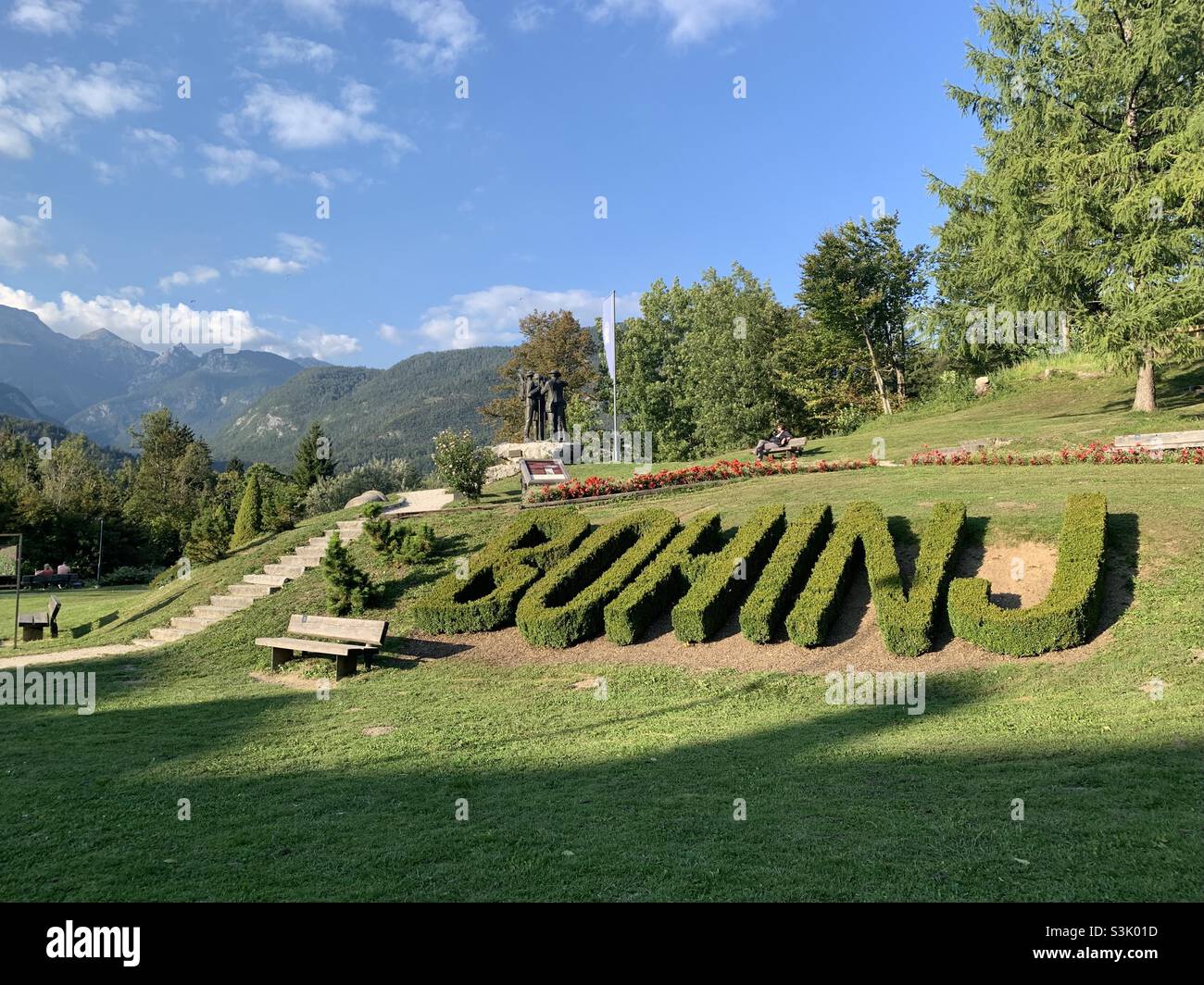 Bohinj word carved into green hillside hedge with a. Bench next to it ...
