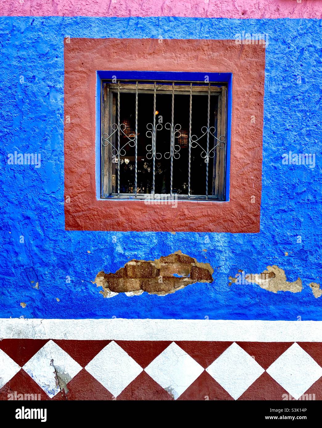Painted plaster wall and gated window in downtown Cabo San Lucas Mexico ...