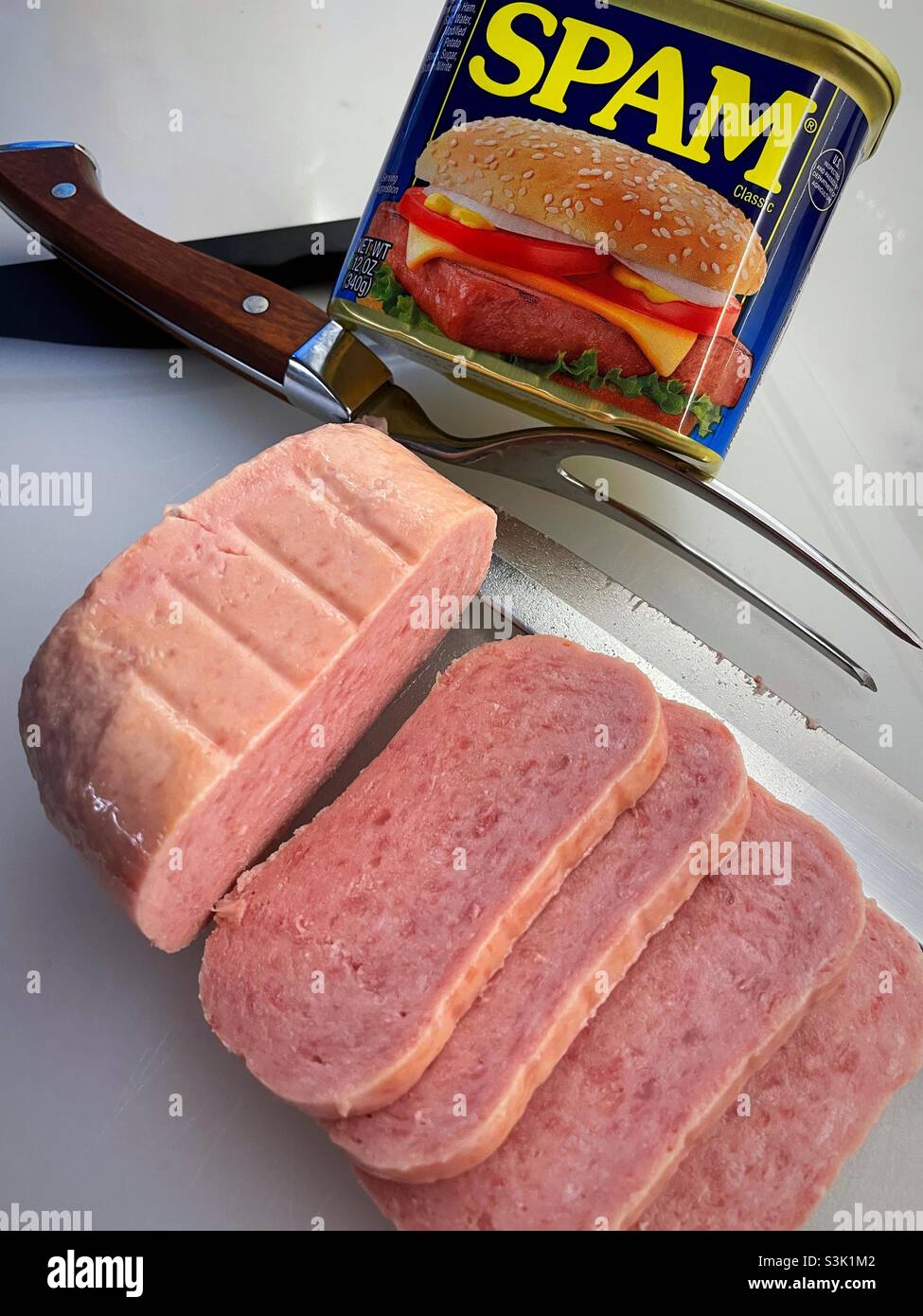 Slices of spam, canned cooked pork product on a cutting board with a ...
