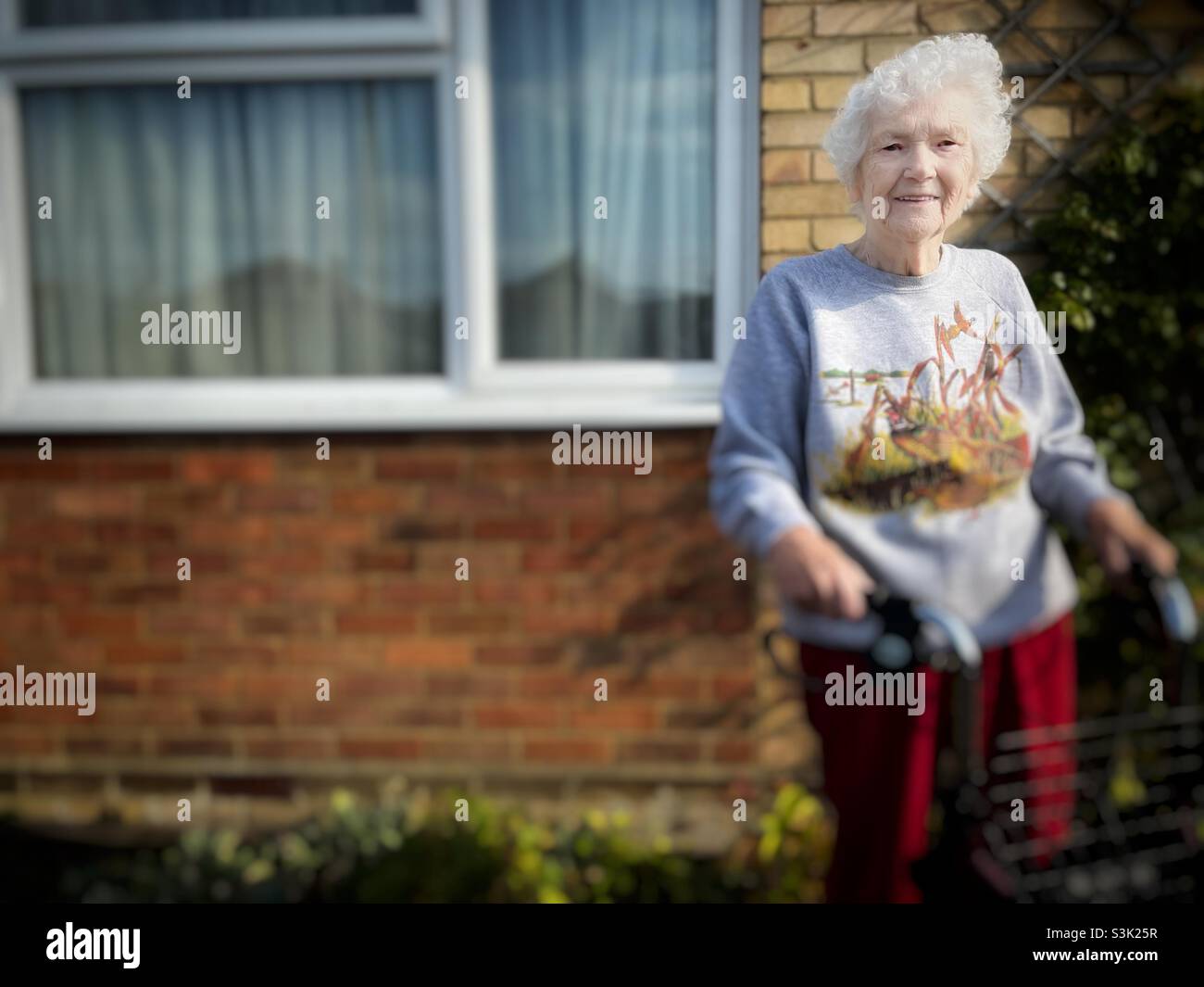 Elderly woman outside her house Stock Photo - Alamy
