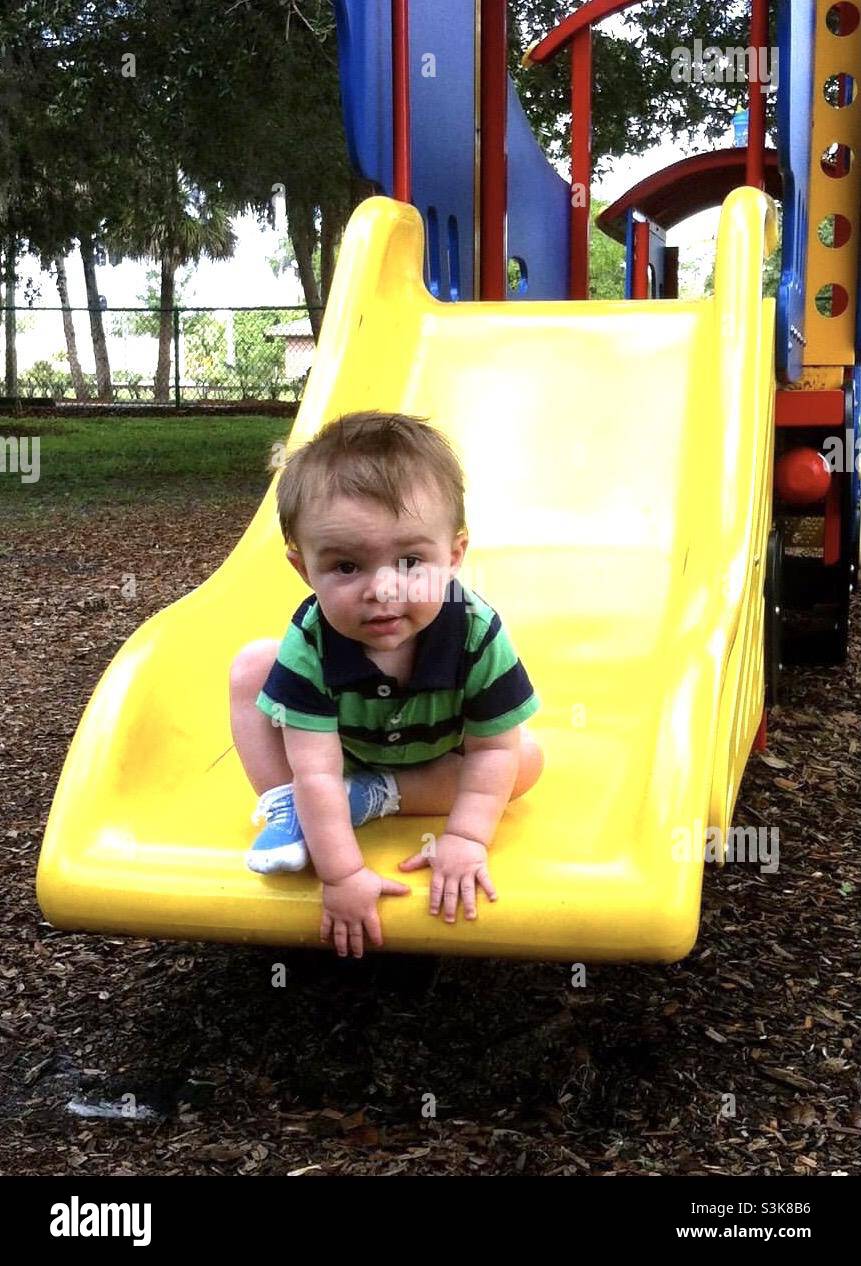 Baby on slide at playground Stock Photo - Alamy