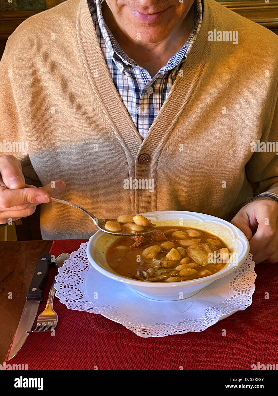 Man eating beans stew Stock Photo - Alamy