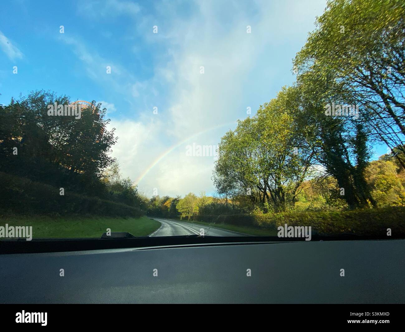 A photograph from inside a car looking out at a road surrounded by ...