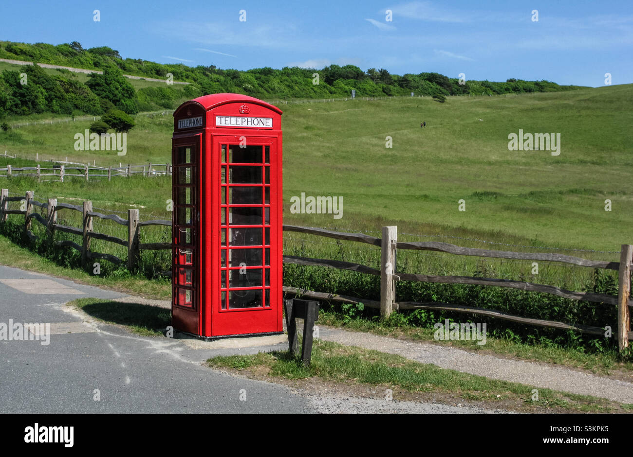 An old style, British red telephone box in a green and rural setting ...