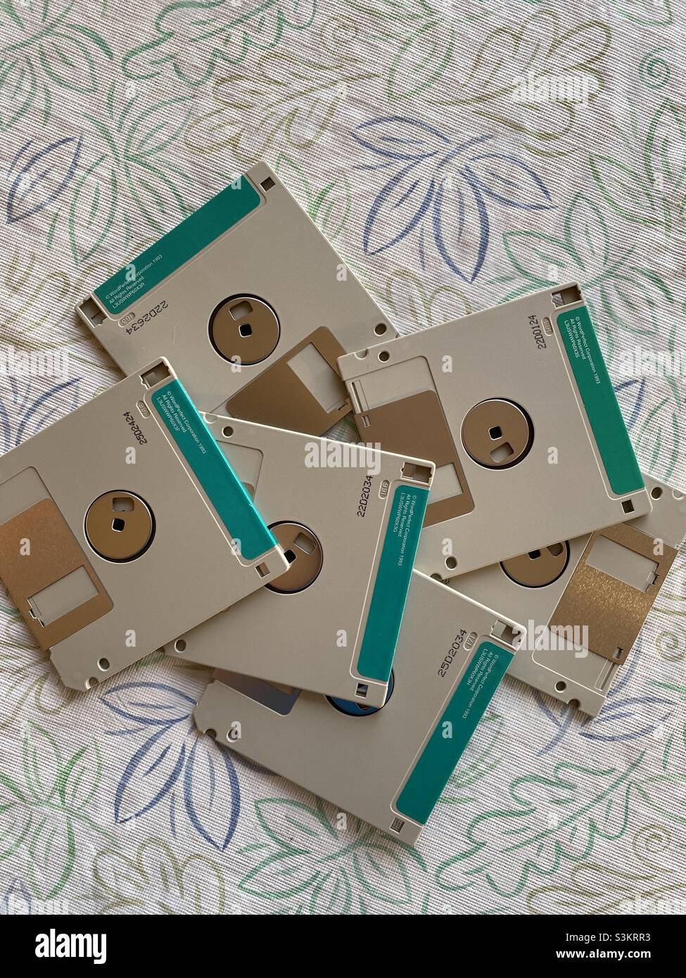 A pile of old floppy discs on a background of vintage vinyl tablecloth ...