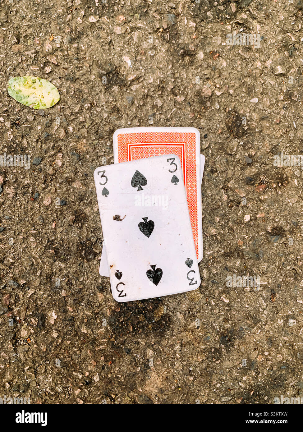 Dirty playing cards left on the pavement Stock Photo - Alamy