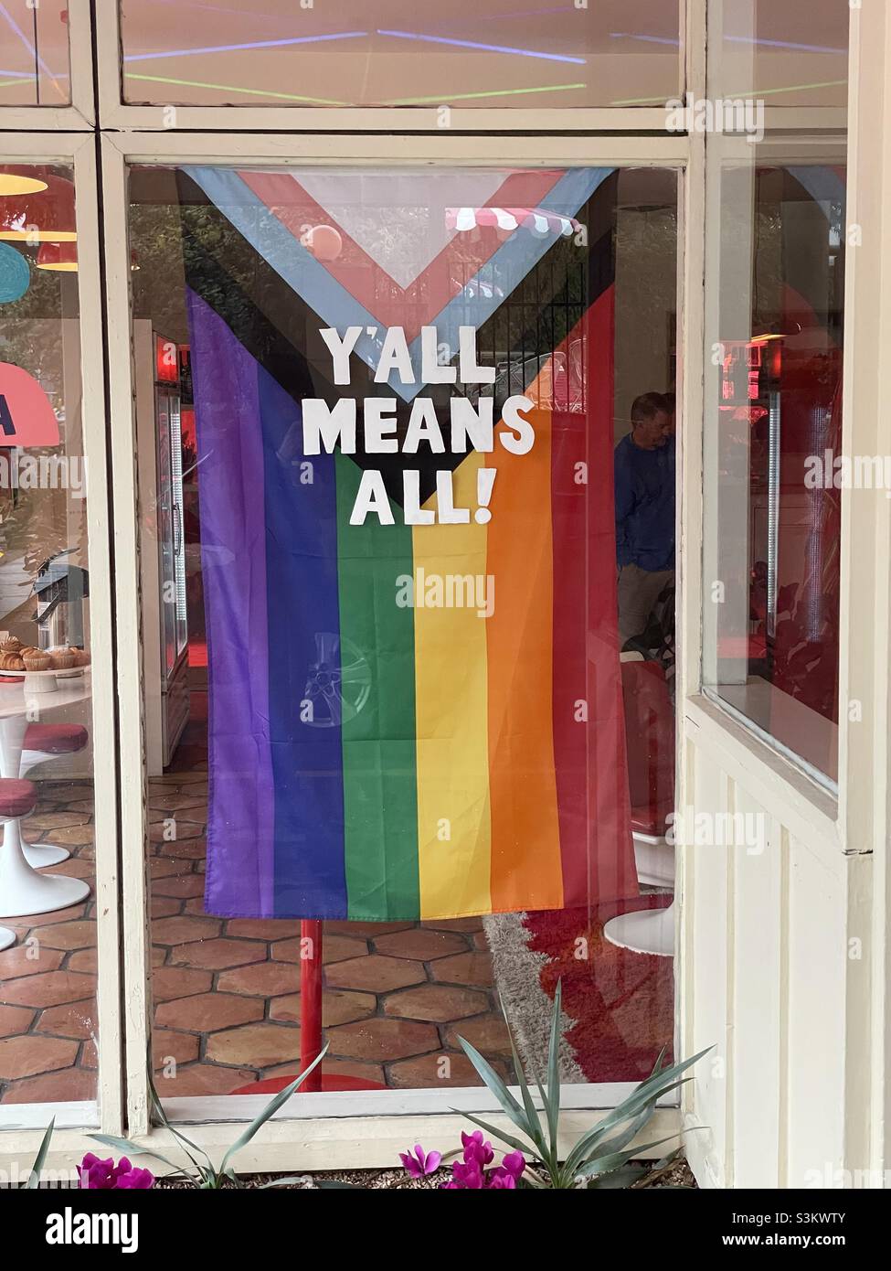 Inclusive flag hanging in a shop window in Texas Stock Photo - Alamy
