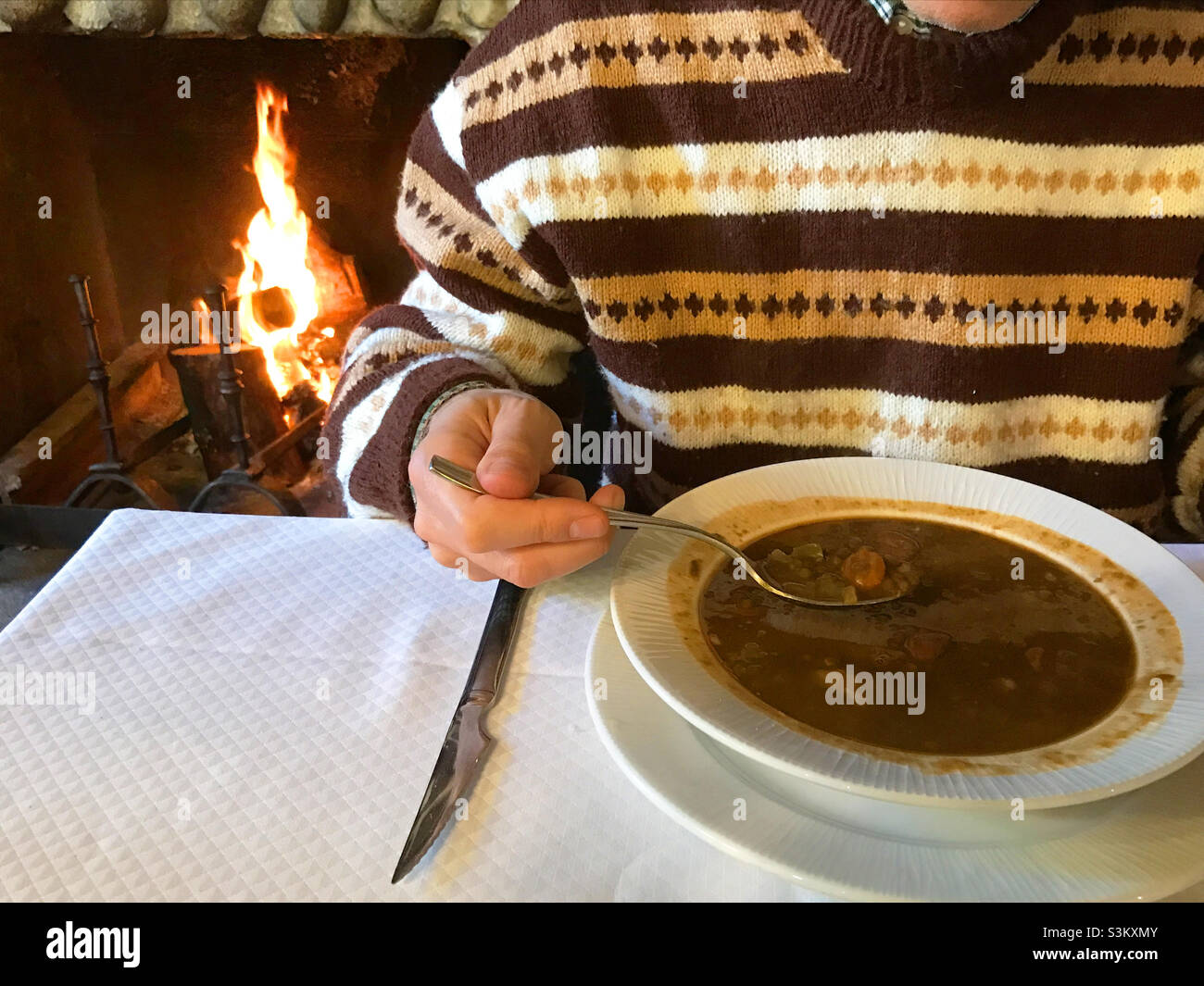 Man eating lentils stew by the hearth Stock Photo - Alamy