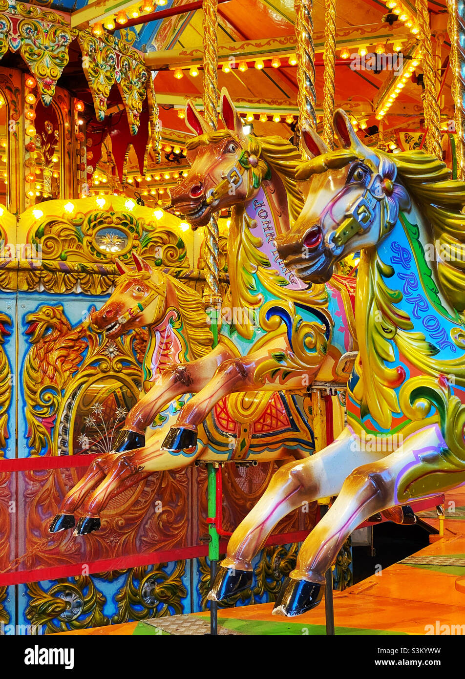 Three horses await riders on a merry go round carousel at a fair ground ...