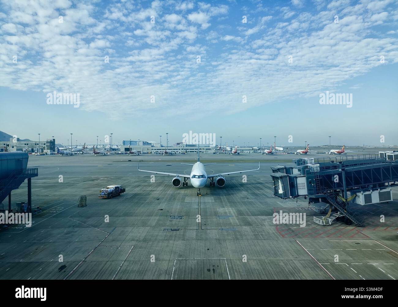 An airplane on the tarmac by the gate at HKIA in Hong Kong Stock Photo ...
