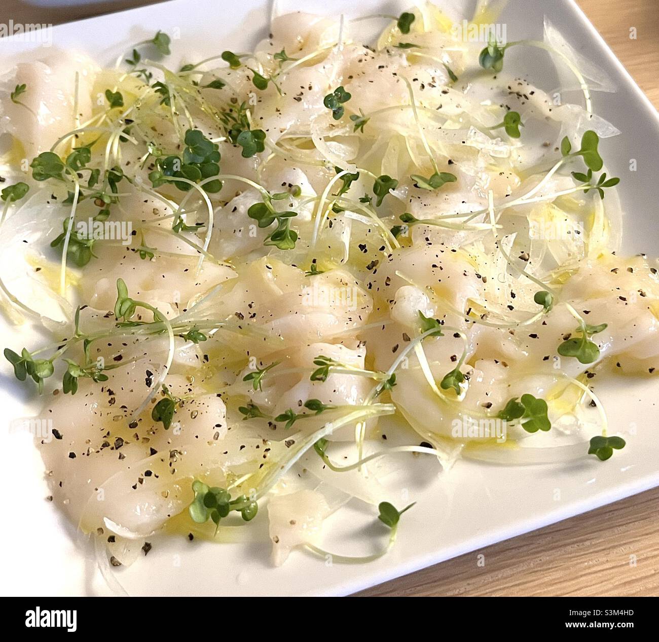 Homemade scallop carpaccio on a white plate Stock Photo - Alamy
