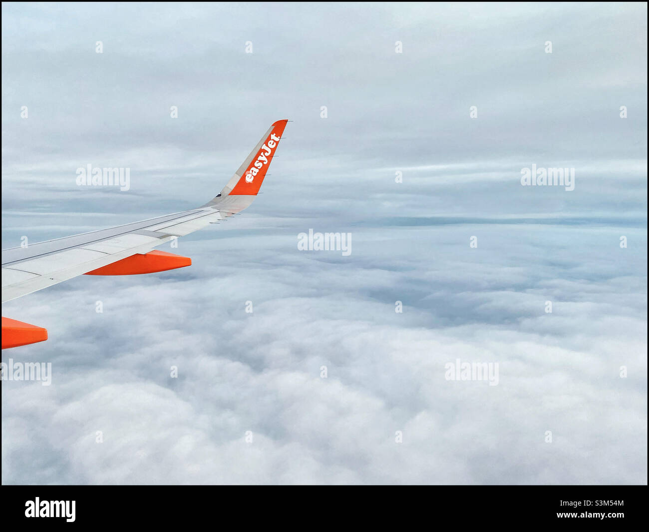A view out of an easyJet aircraft window. The plane is cruising above ...