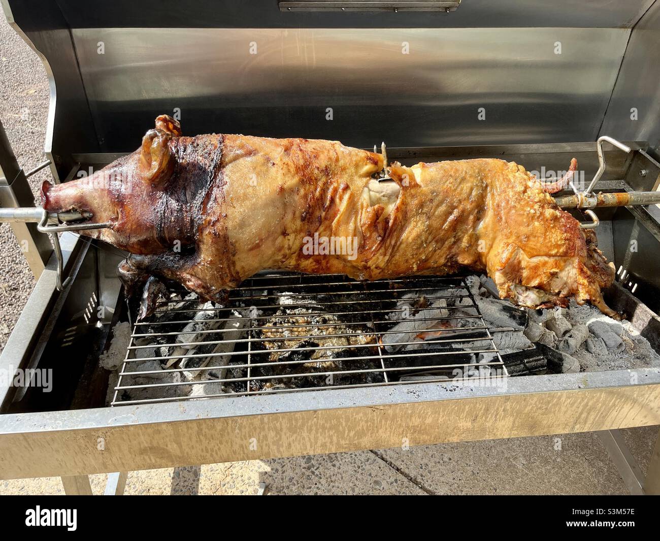 Piglet roasting on a spit Stock Photo - Alamy