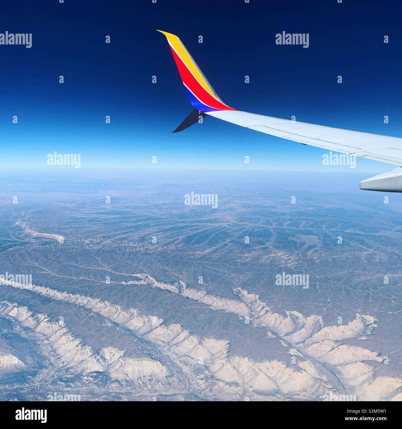 Wing of a Southwest Airlines airplane over a mountainous landscape in ...
