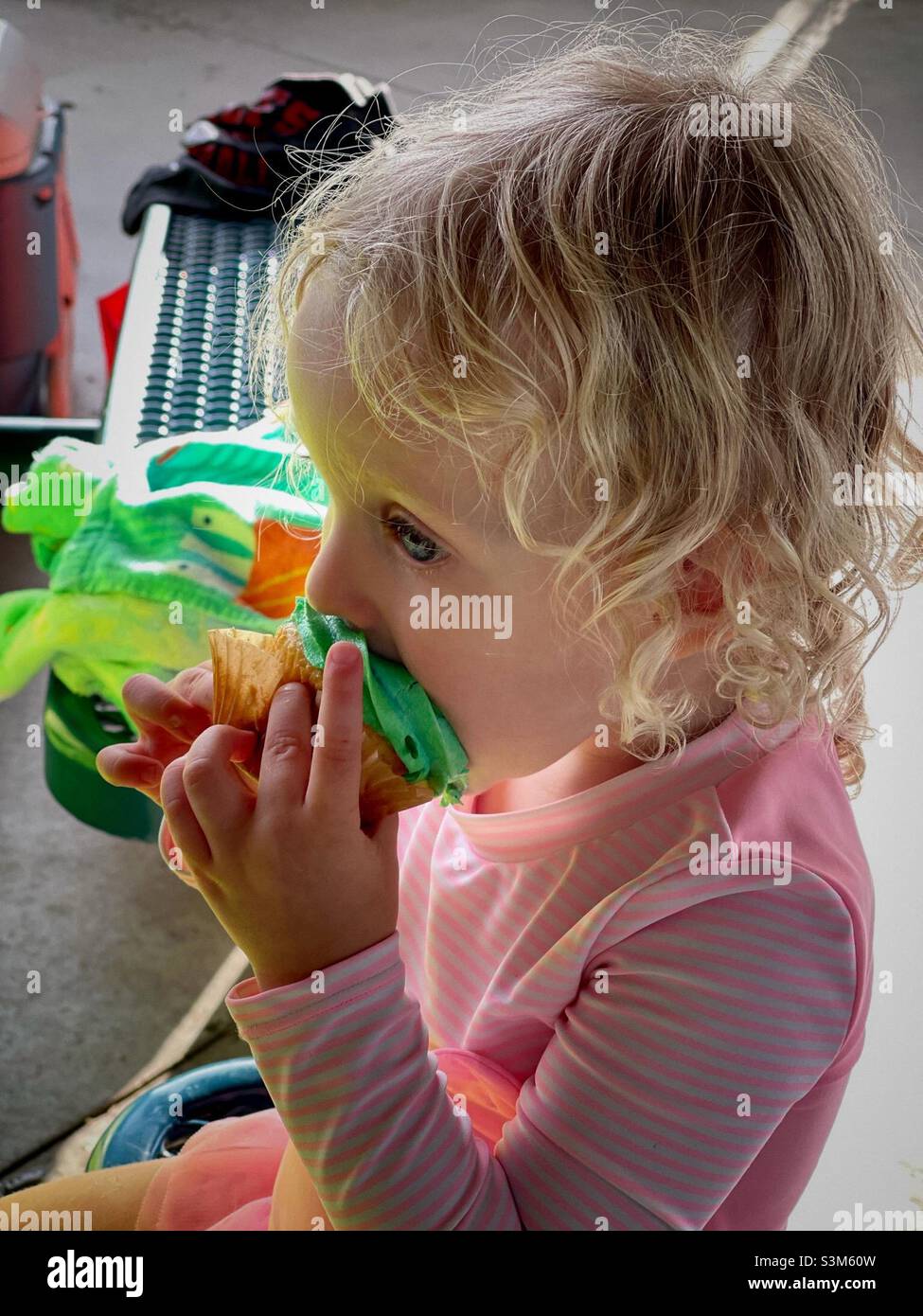 Two year old toddler birthday girl eating cupcake with green frosting ...
