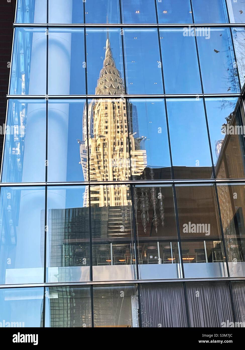 The reflection of the iconic Chrysler building in the glass façade of ...
