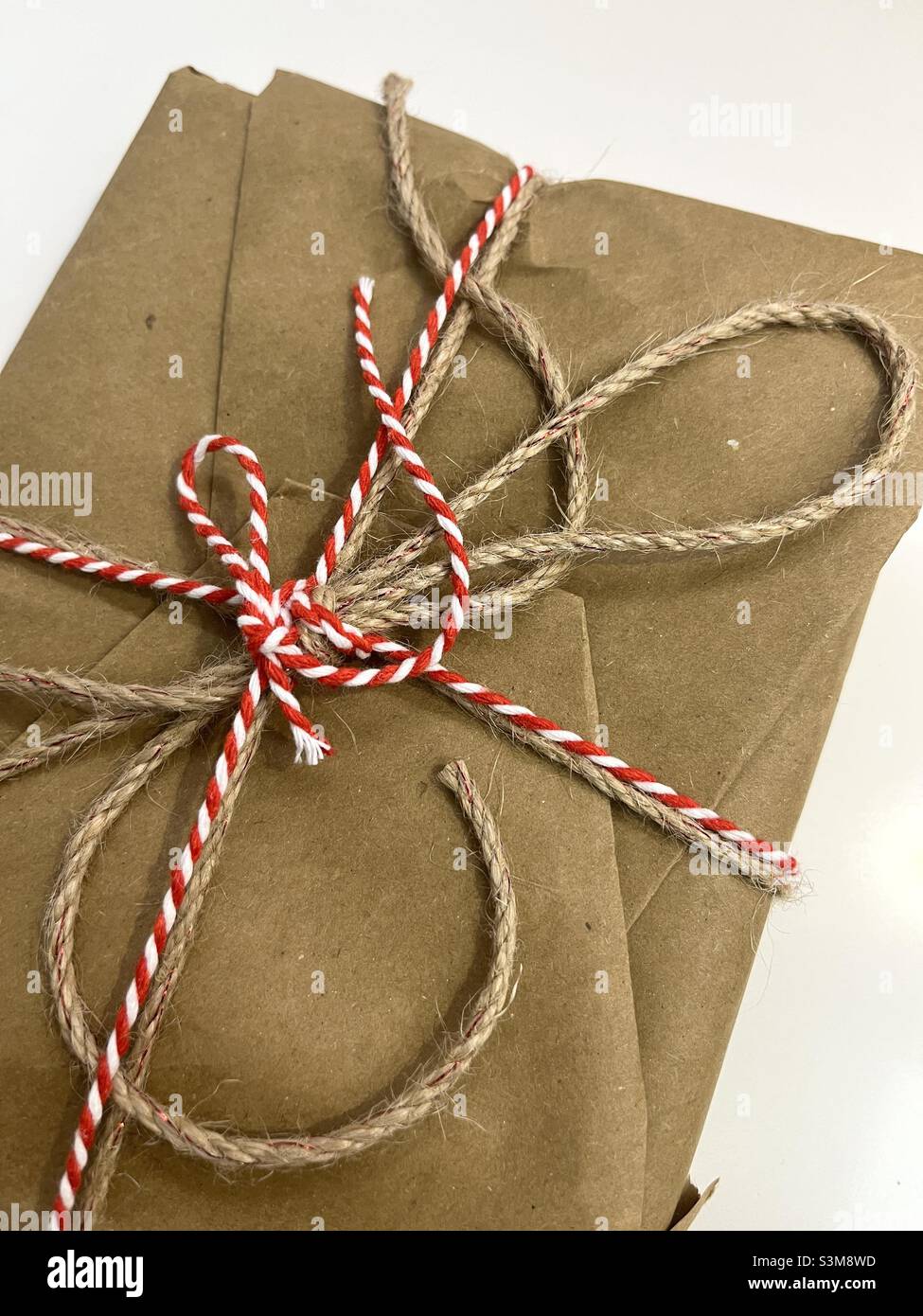 Gift wrapped with brown paper and tied with string Stock Photo - Alamy