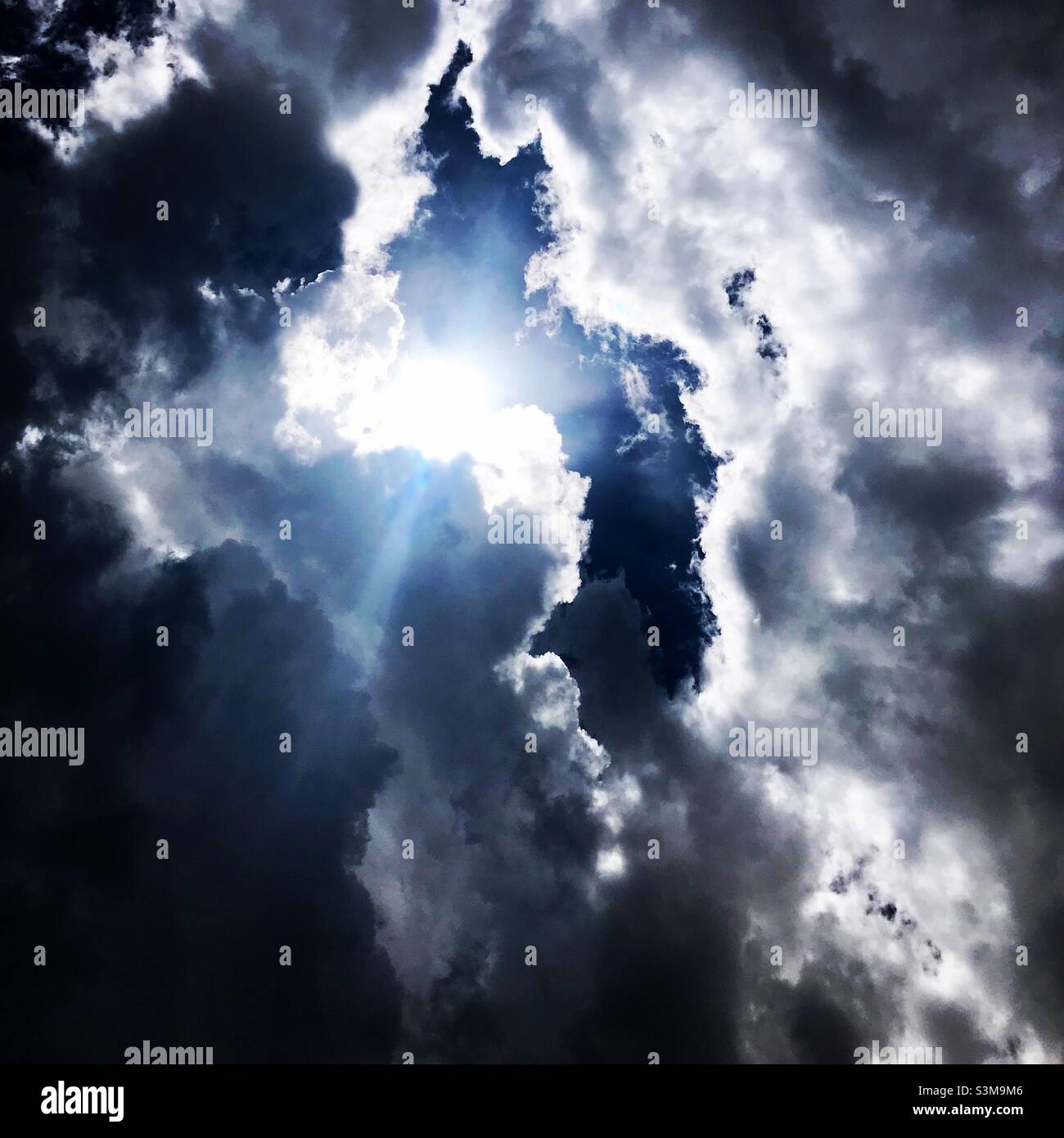 Sun through clouds Stock Photo - Alamy