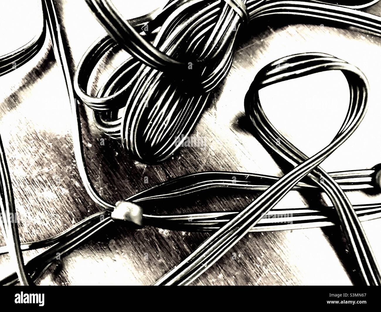 Tangled head phone cords on a desk Stock Photo - Alamy