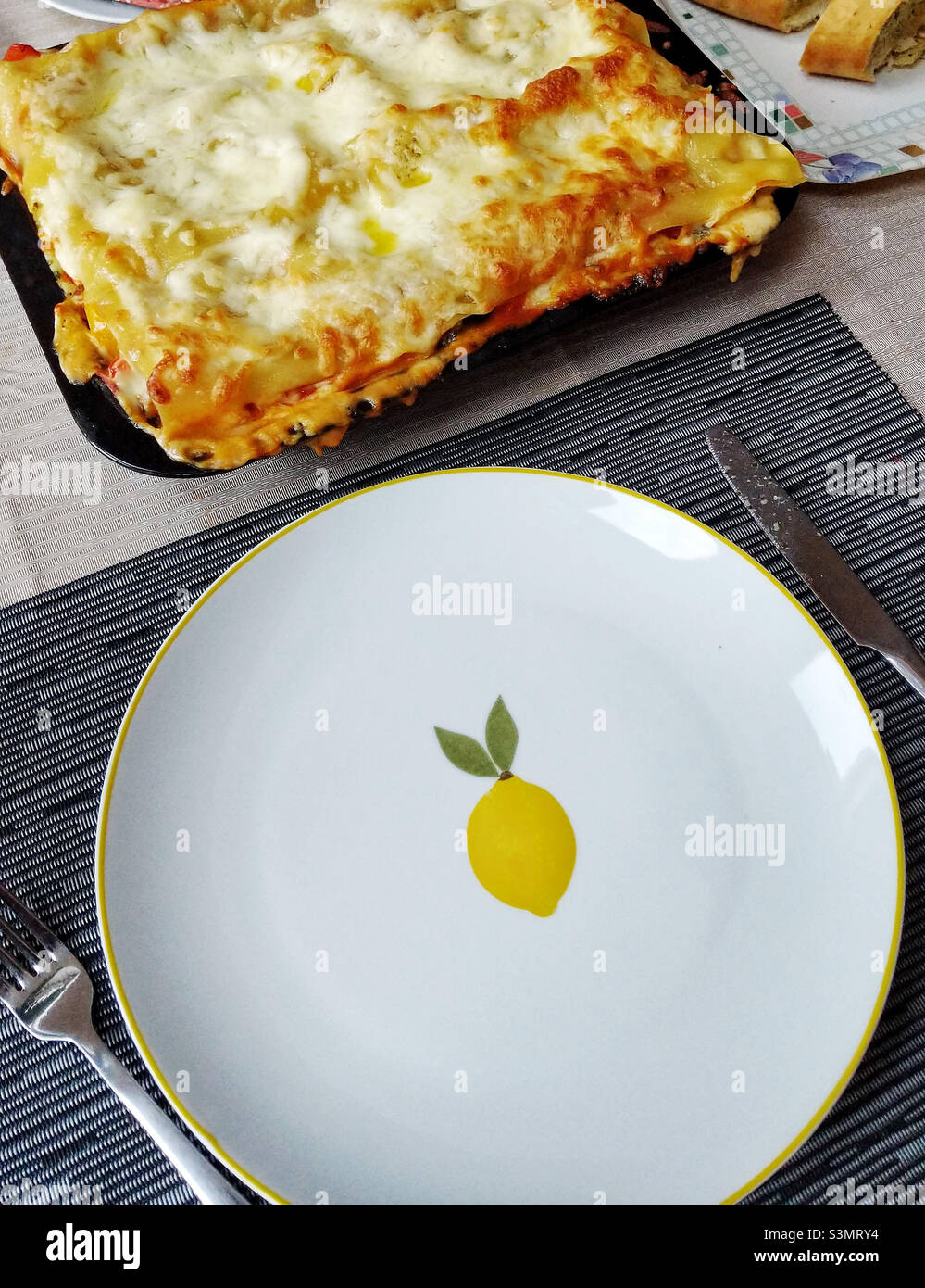 Dinner table top down view of empty white plate with lasagne food in a ...