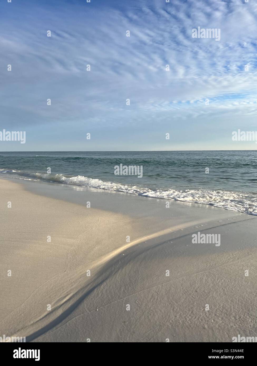 Patterns and textures in beach sand with view of Gulf of Mexico water ...
