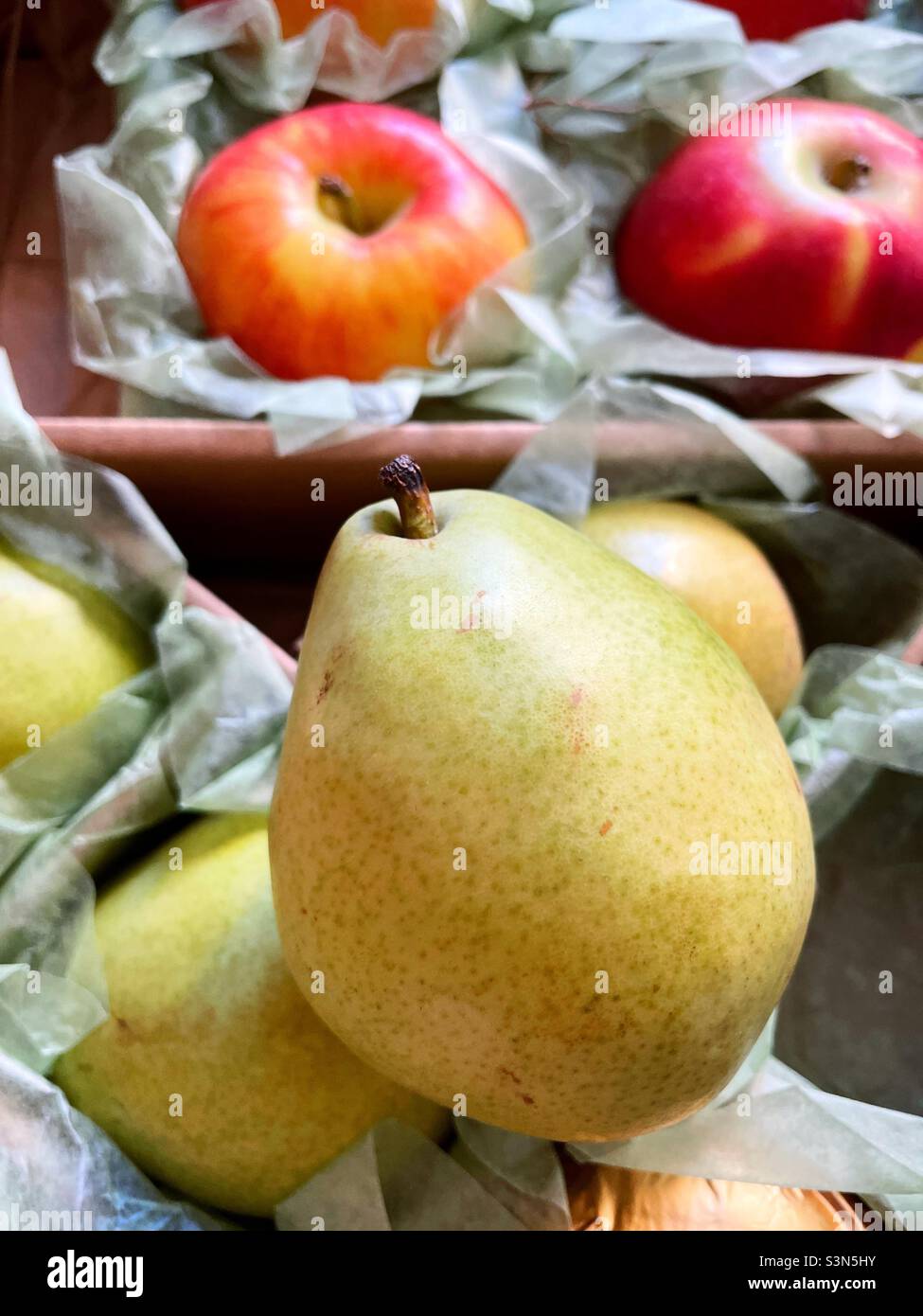 Pears and apples wrapped in paper in a cardboard delivery box, 2022 ...