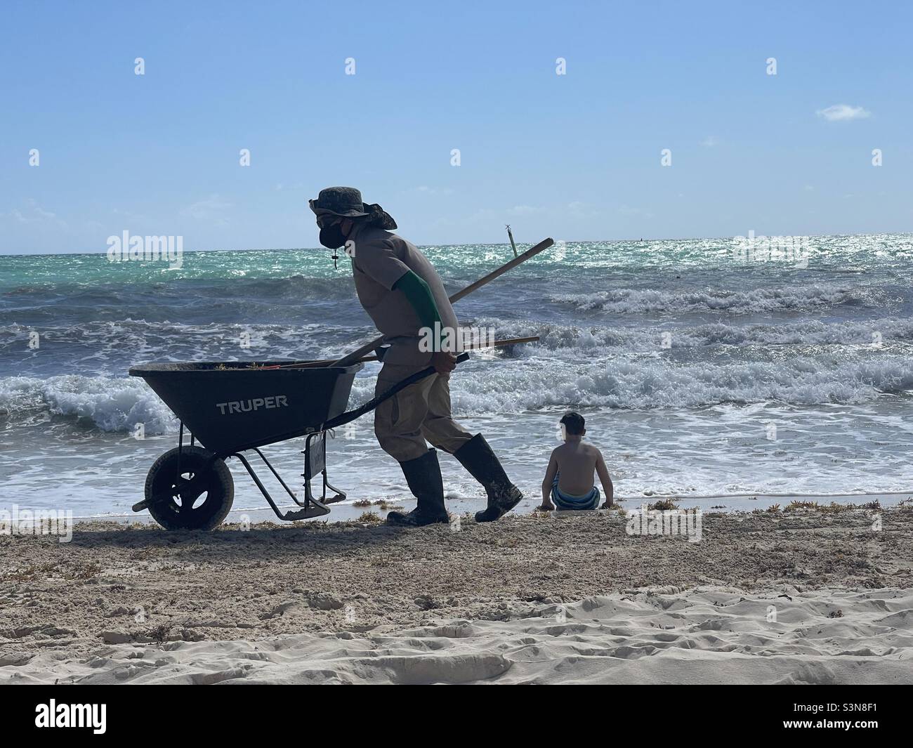 Silhouetted man pushing wheelbarrow hi-res stock photography and images ...