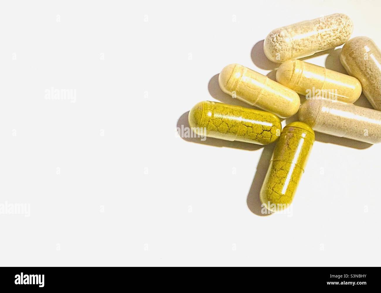 Closeup of supplement capsules on a bright white background with copy ...
