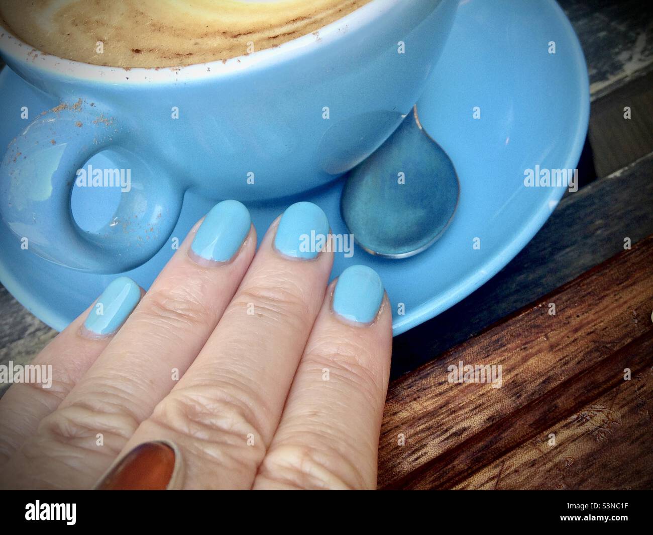 Blue nails to match a blue coffee cup. Random colour choice Stock Photo ...
