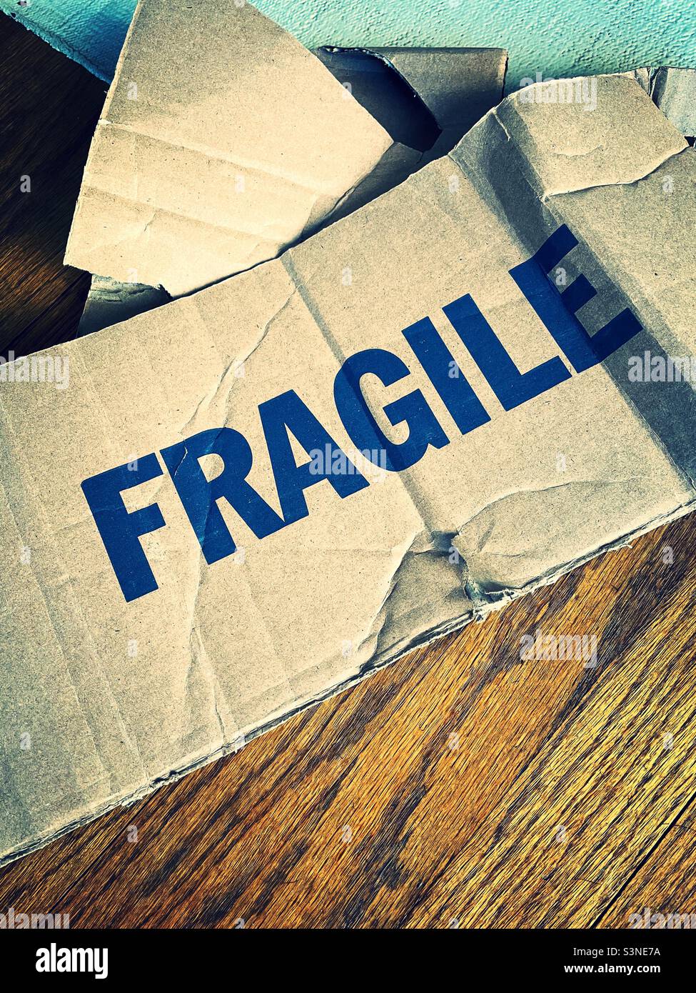 A crushed cardboard box marked fragile Lays destroyed on a wooden floor, 2022, USA Stock Photo ...