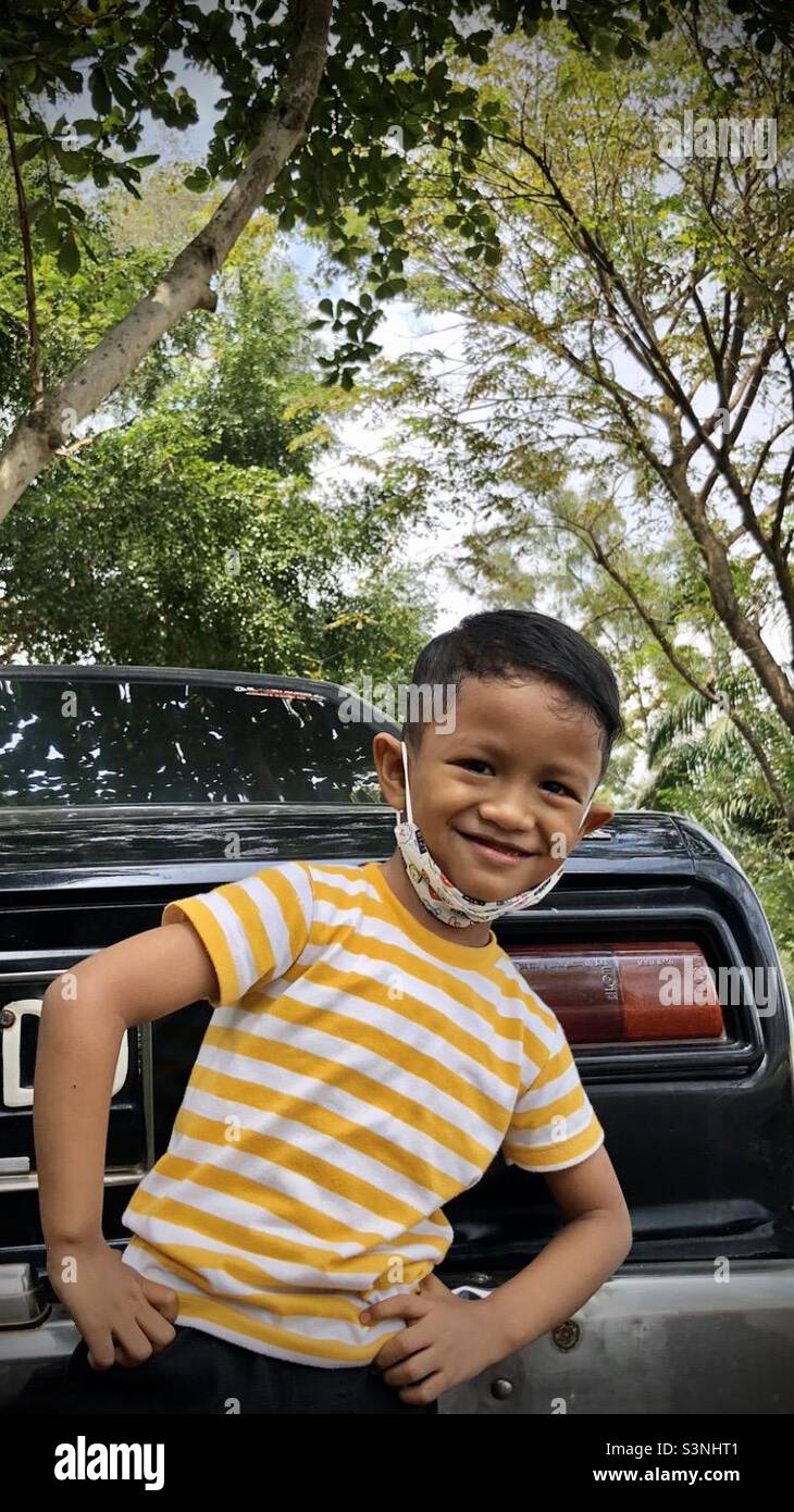 a stylish little boy follows the direction of his parents this photo ...