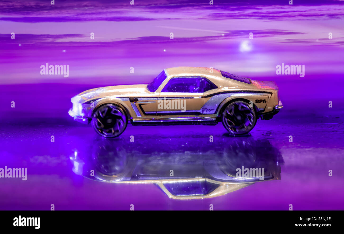 Gold car driving through purple landscape - fake scene with toy car ...