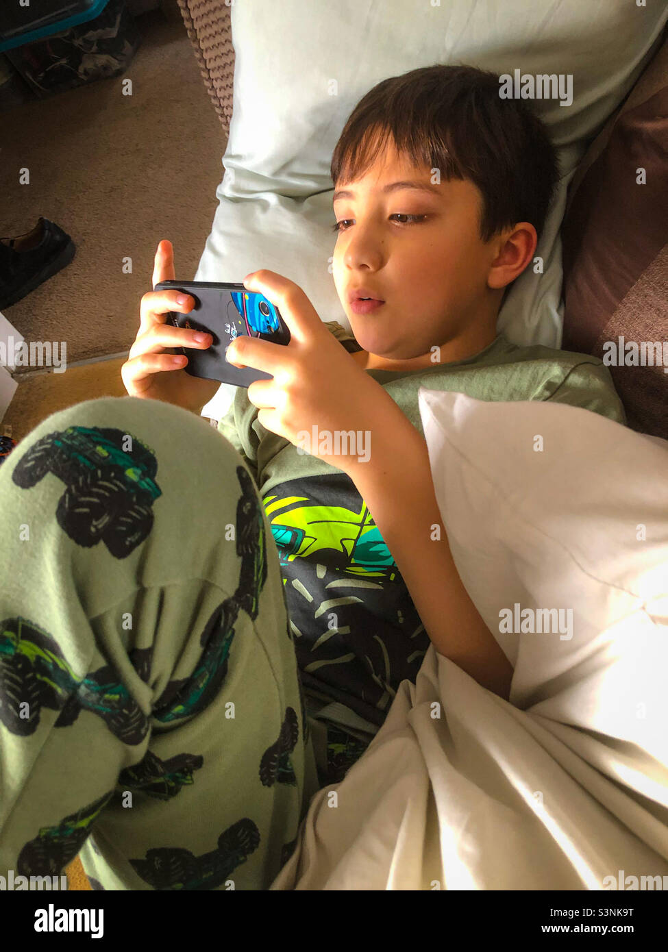 Boy playing cellphone lying on hi-res stock photography and images - Alamy