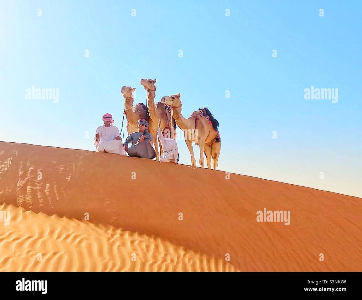 Desert people: 3 nomads sitting on the desert hill with their camels ...