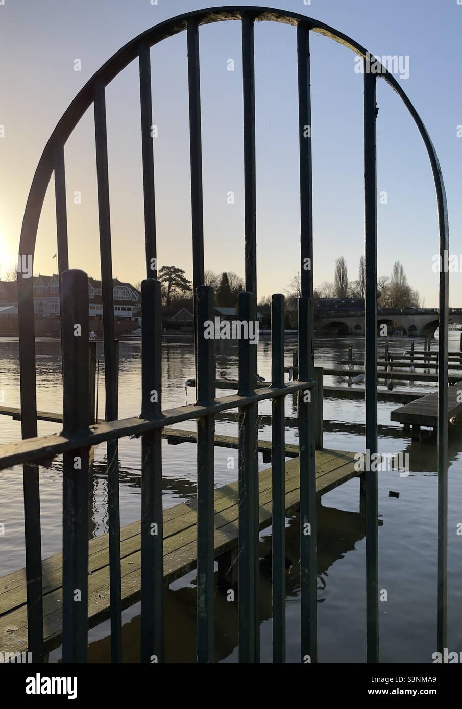 A curved iron gate on the deserted landing stages by the Thames in ...