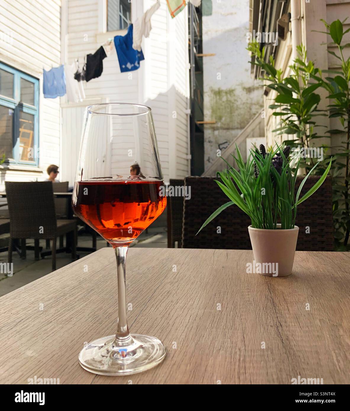 Glass of Rosé wine at wine bar in Italian inspired courtyard with ...