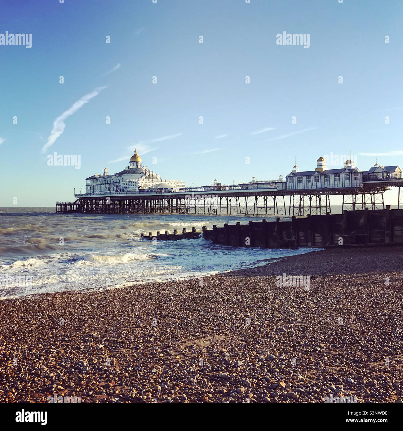 The pier stretches out into the sea from the shingle beach at ...
